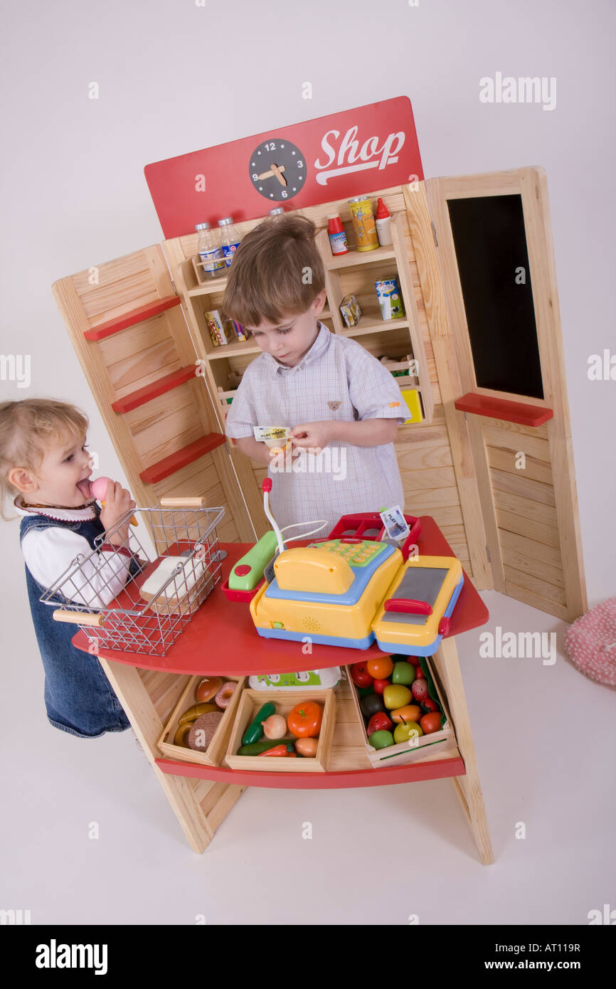 little boy and little girl playing in grocery shop for children Stock ...