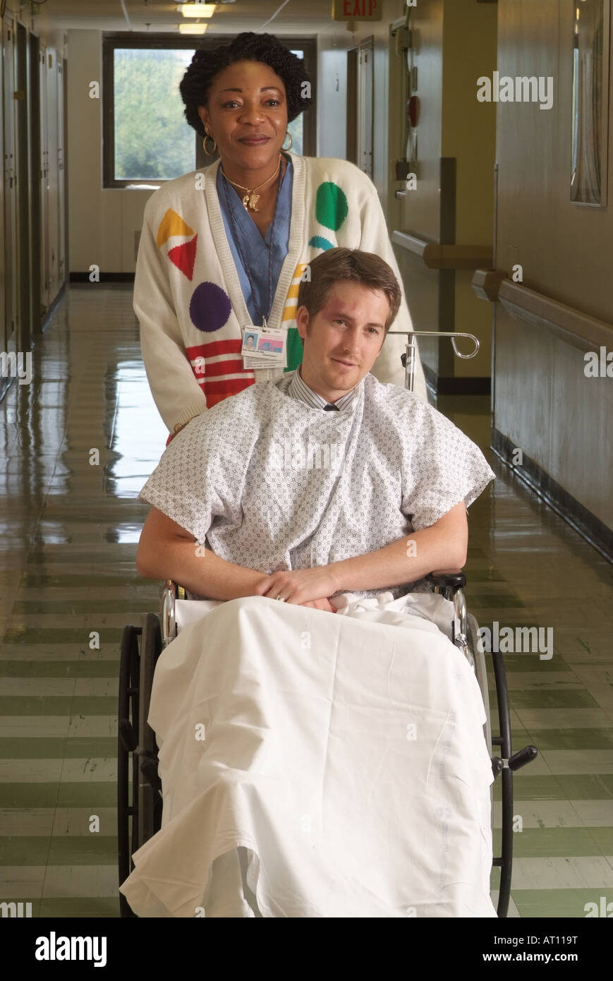 Heath Care Nurse wheels a patient down the hallway Stock Photo - Alamy