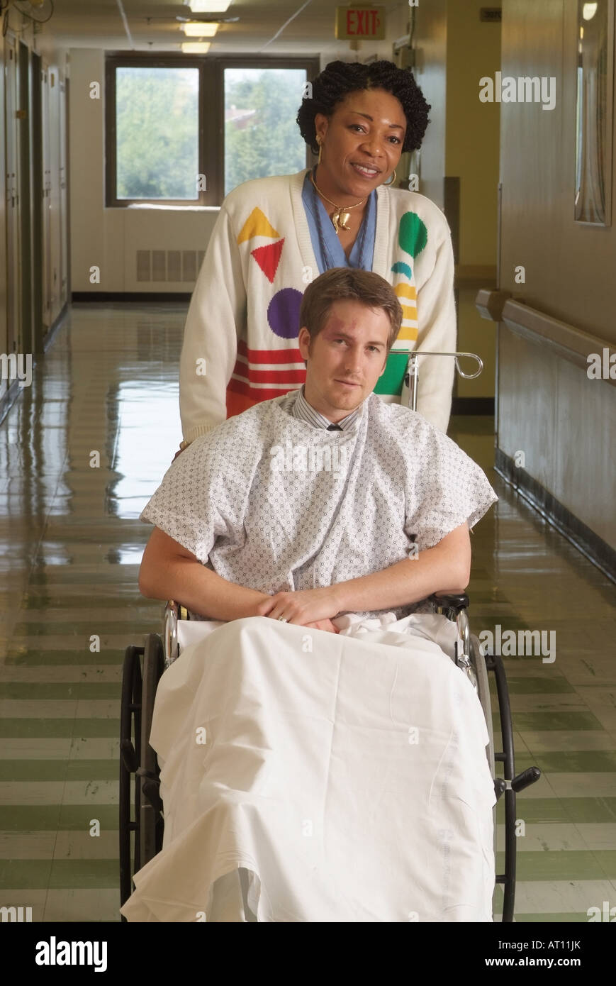 Heath Care Nurse wheels a patient down the hallway Stock Photo - Alamy