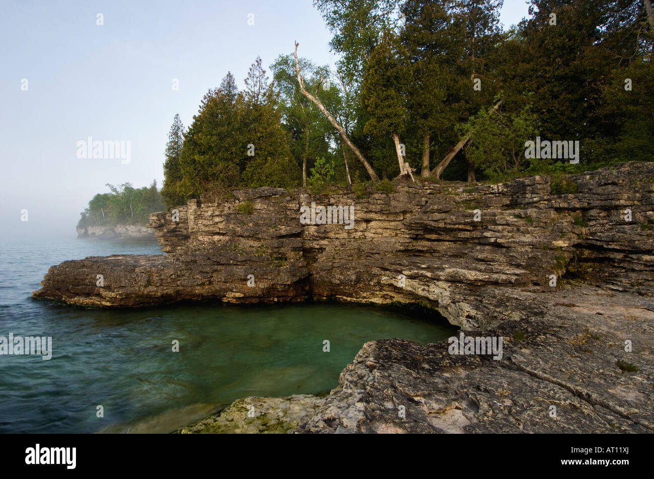 Rocky Cliffs and Approaching Morning Mist on Lake Michigan at Cave ...