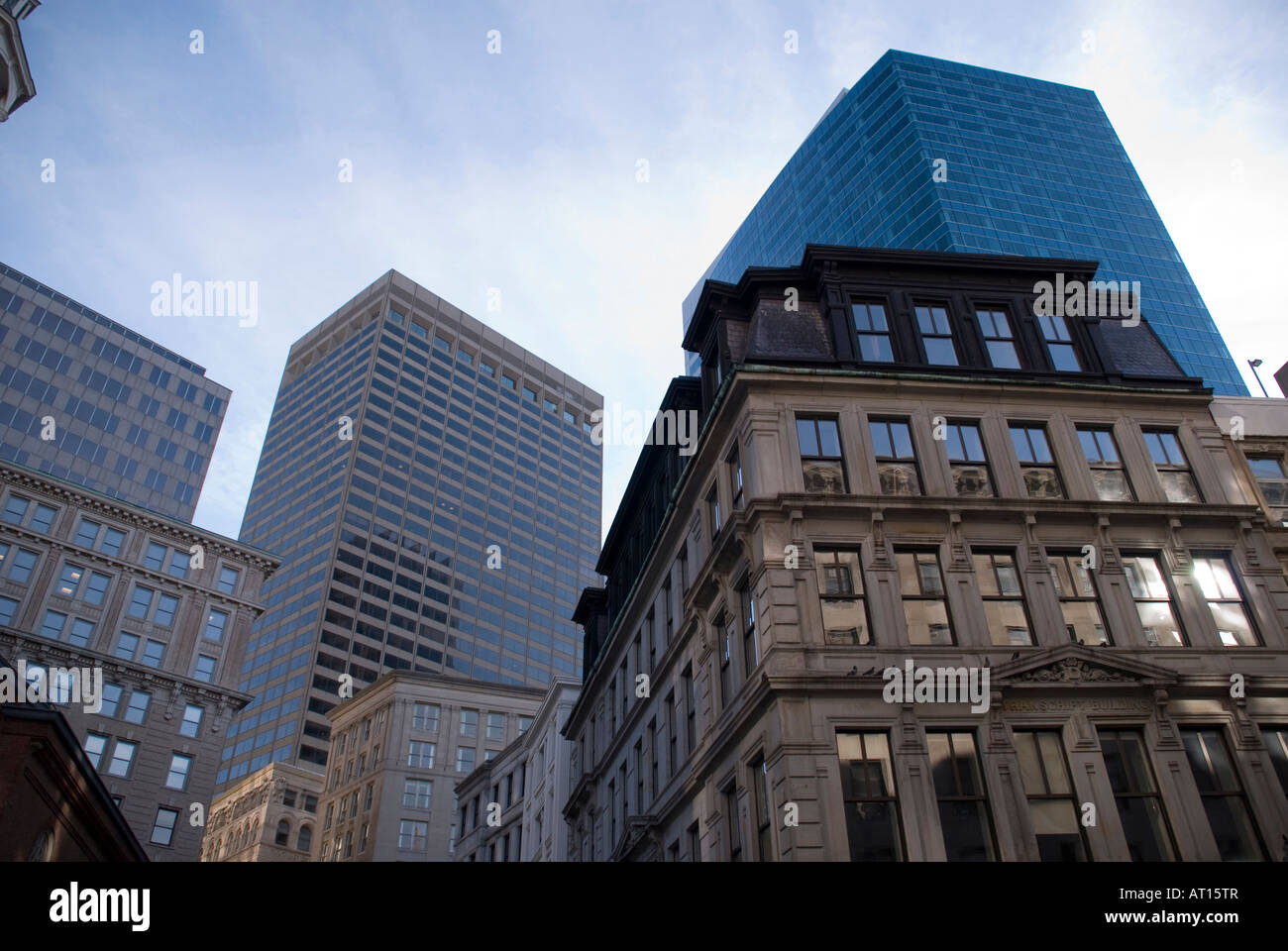 Corporate building towers over some small buildings Stock Photo - Alamy