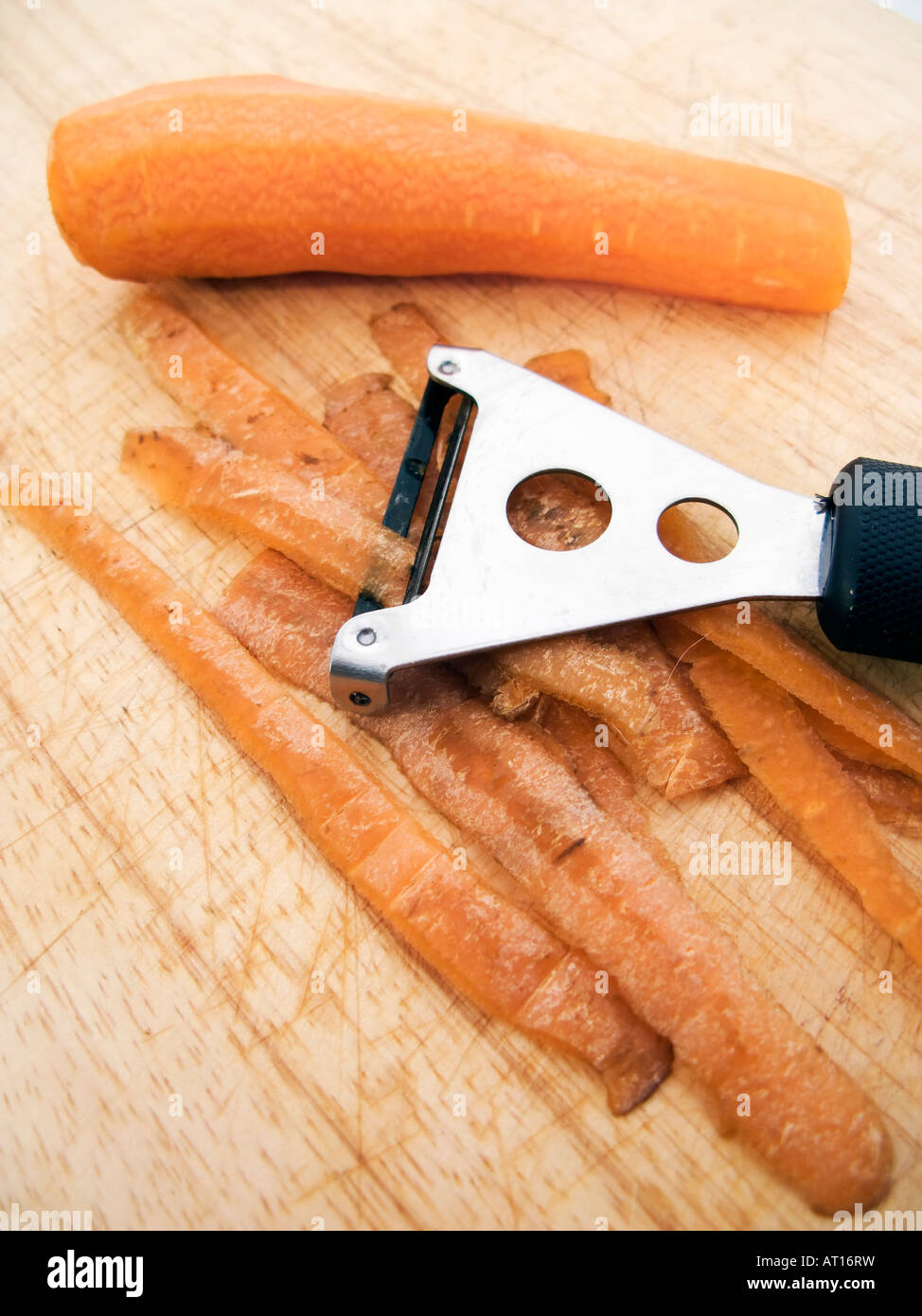 Carrot and peeler over wood board Stock Photo - Alamy