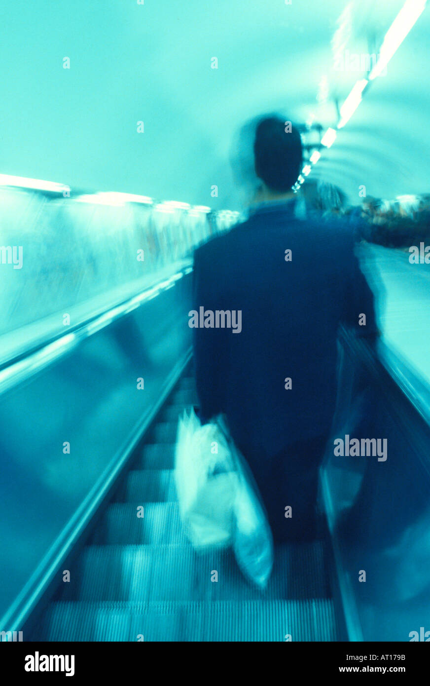 Commuter with shopping on escalator Stock Photo - Alamy