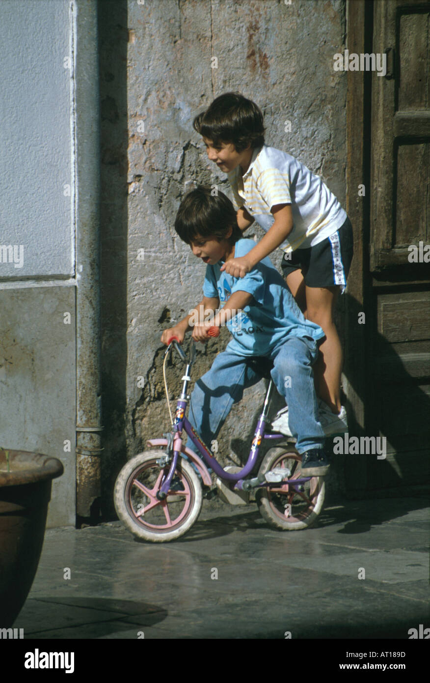 Boys playing with bike Palermo Sicily Stock Photo - Alamy