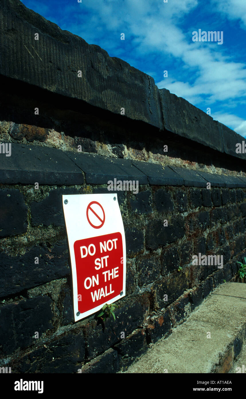 Do not sit on wall sign Stock Photo - Alamy