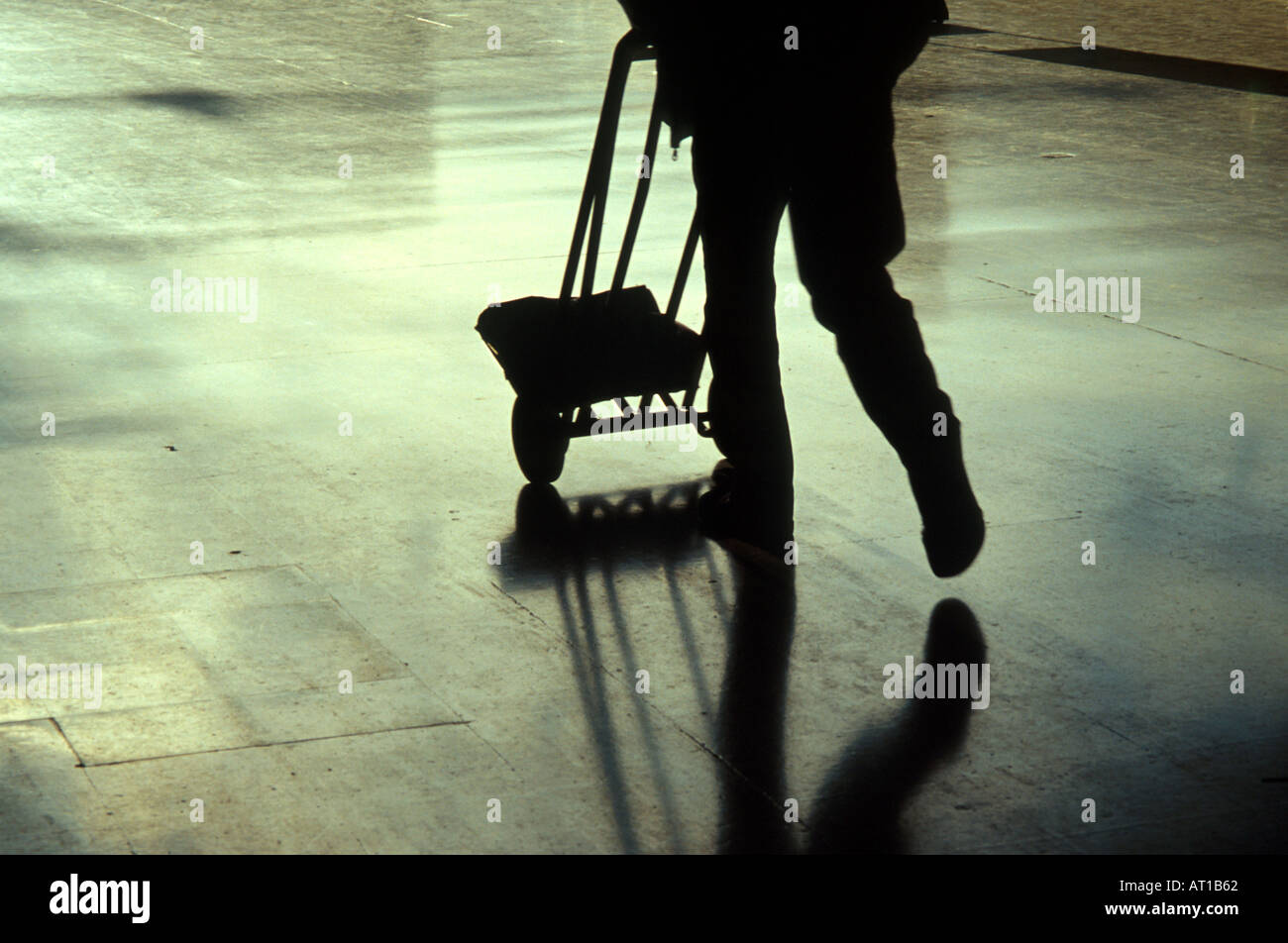 Man walking with trolley at station Stock Photo - Alamy