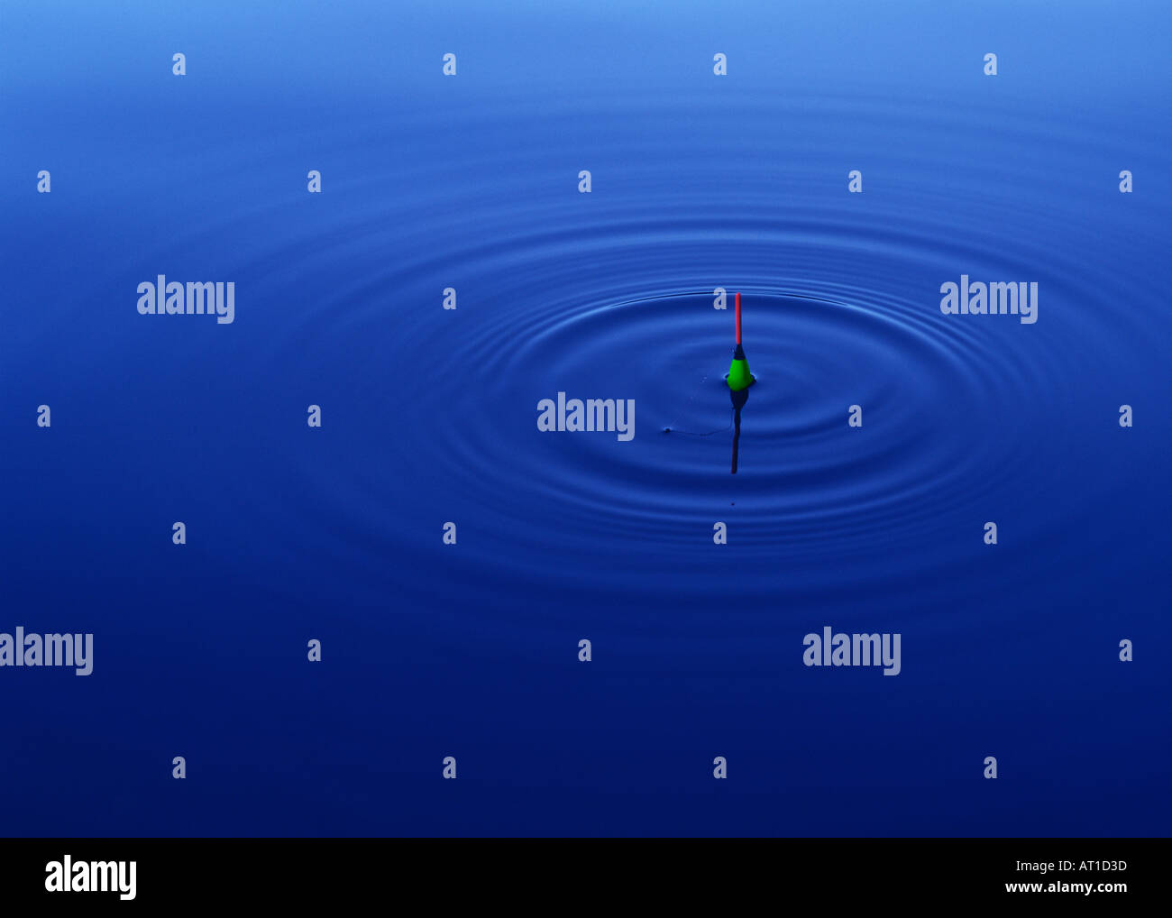Still Blue water with slight ripple and fishing float Stock Photo - Alamy