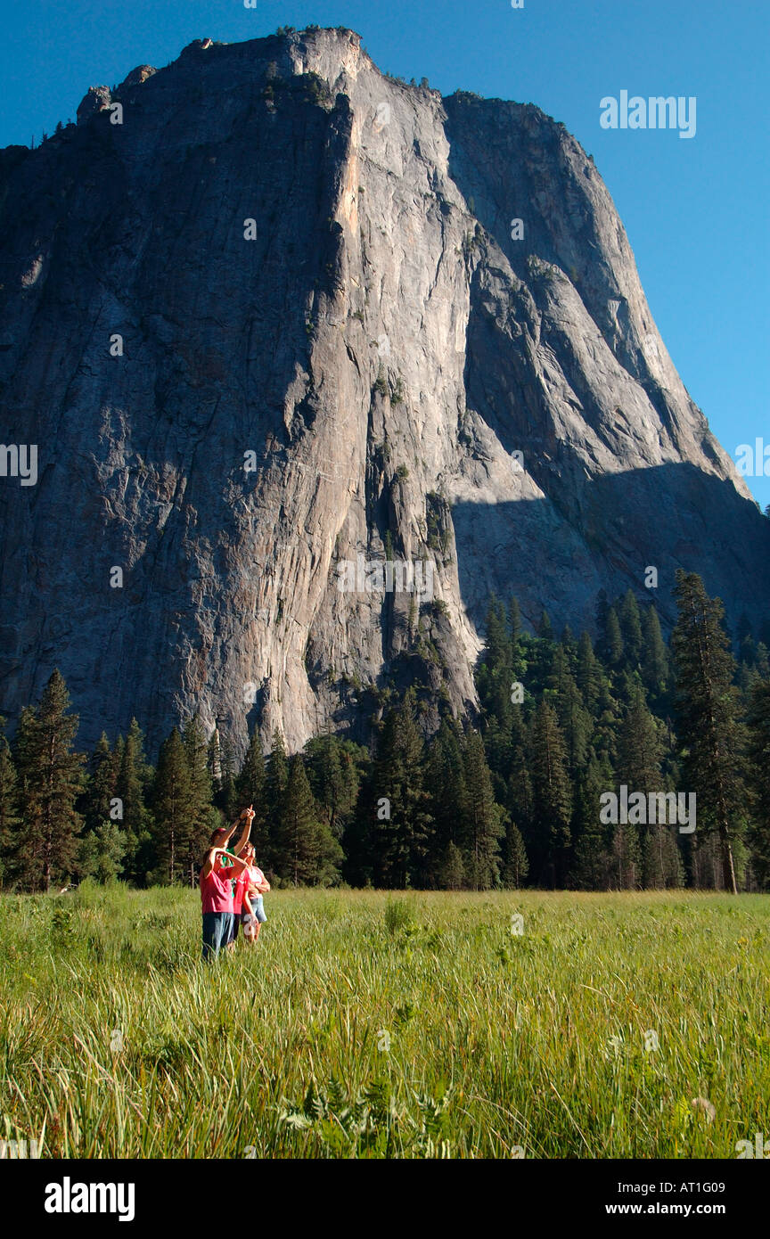 Amazed tourists in a meadow watching rock climbers on El Capitan ...