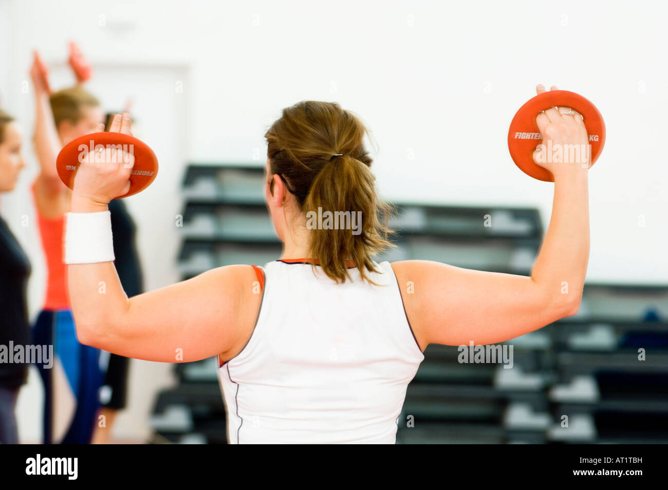 Female aerobics trainer showing body toning with light weights Stock ...