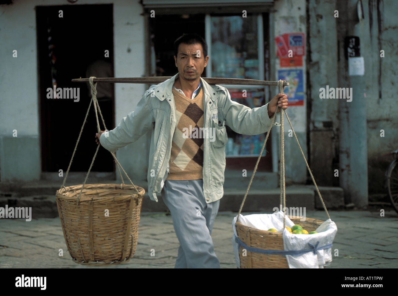 Man carrying baskets in Beijing Stock Photo - Alamy