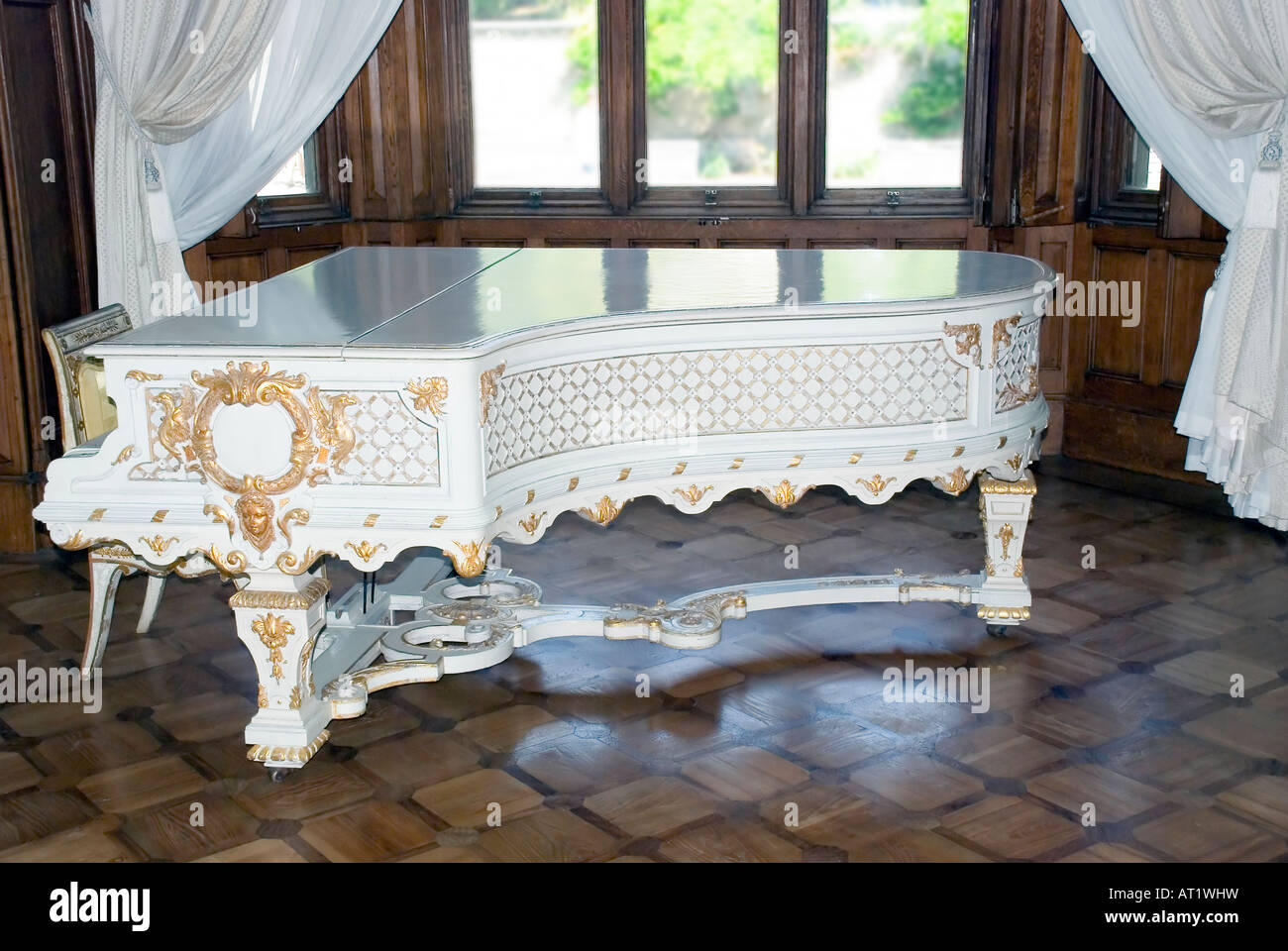 White ancient grand piano trimmed by gold job of the Italian masters ...