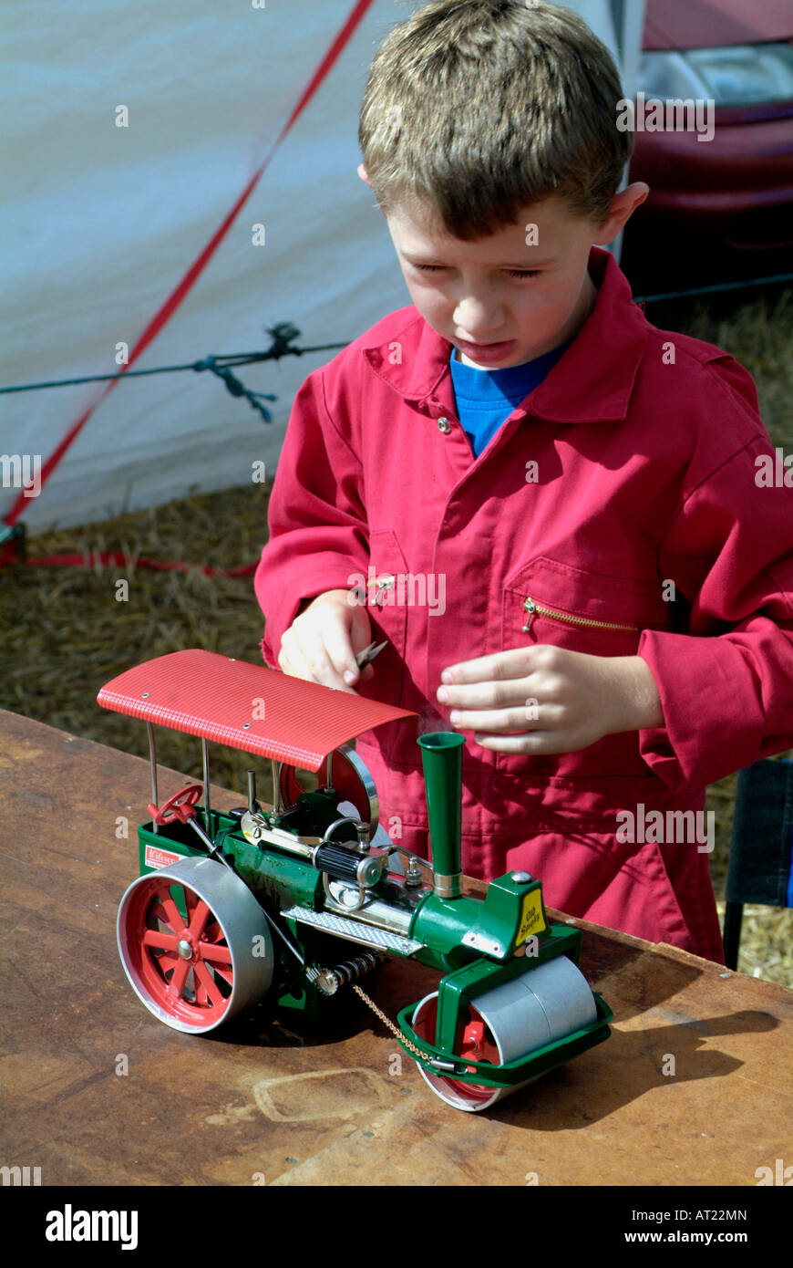 young boy with overalls and toy steam roller Stock Photo - Alamy
