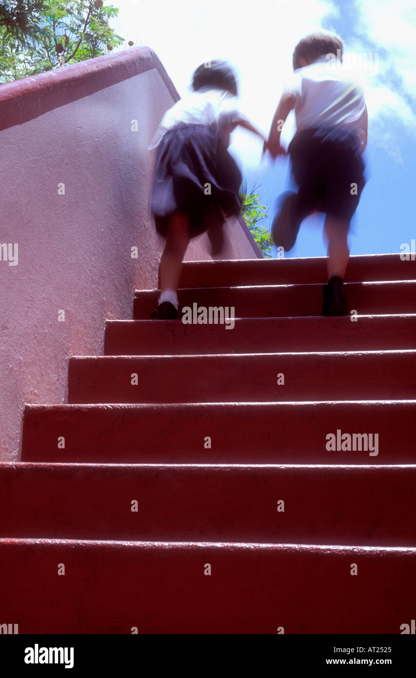 Two Children boy & girl 4-6 years holding hands running upstairs low ...