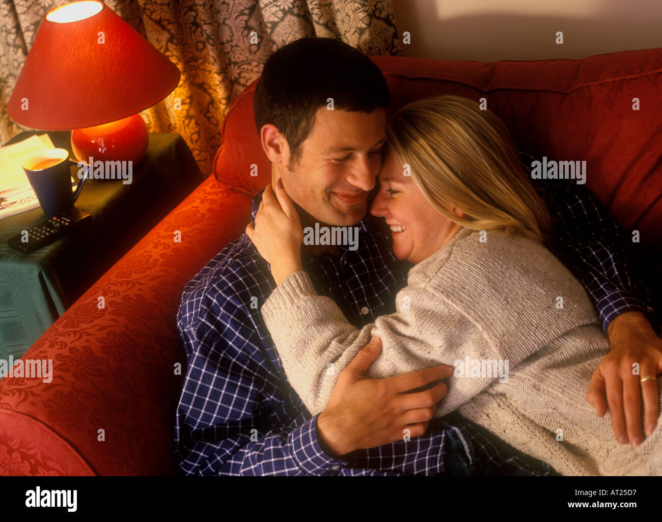 Couple cuddling up on sofa hi-res stock photography and images - Alamy