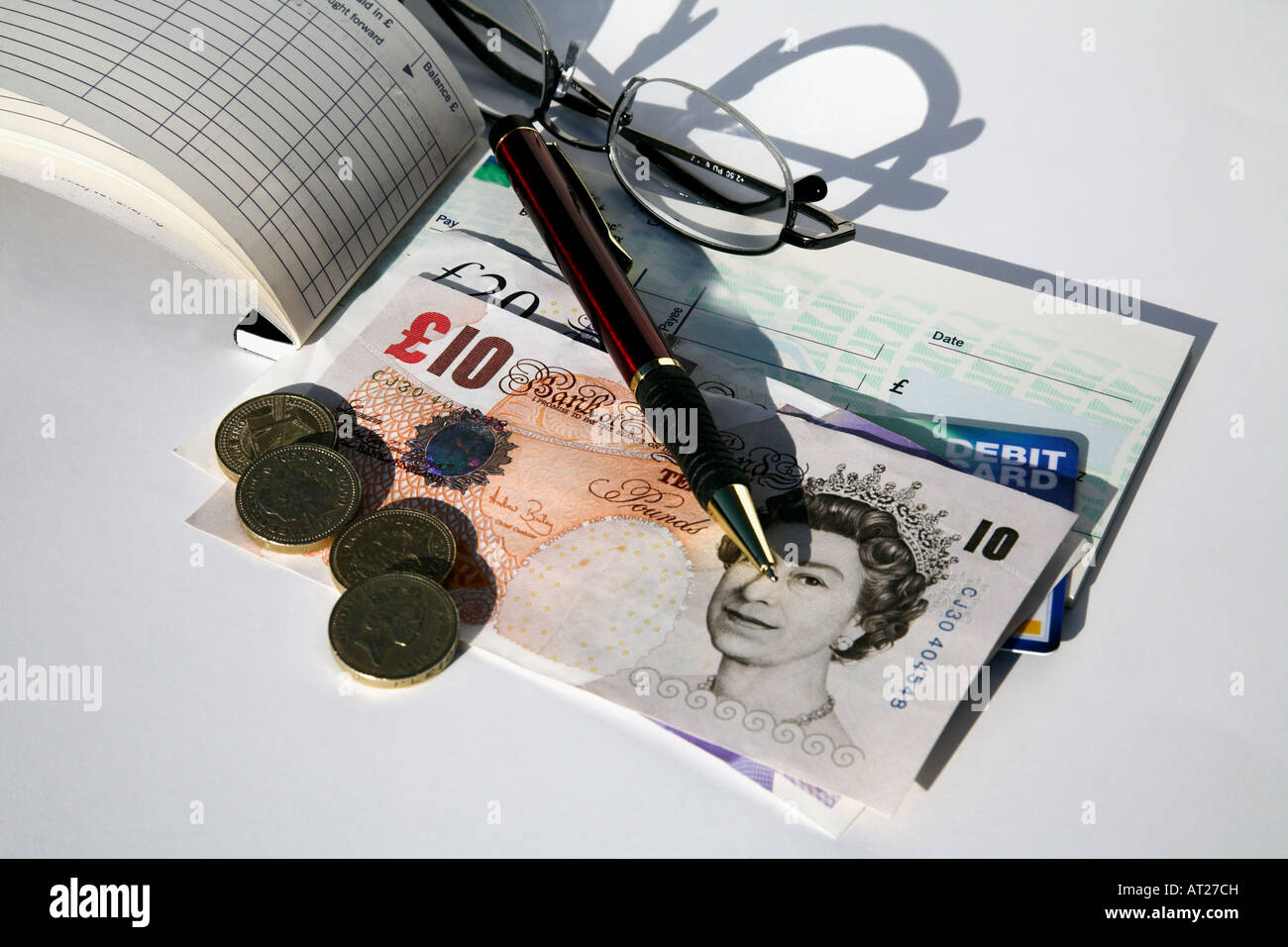 Cheque book with coins and currency Stock Photo - Alamy
