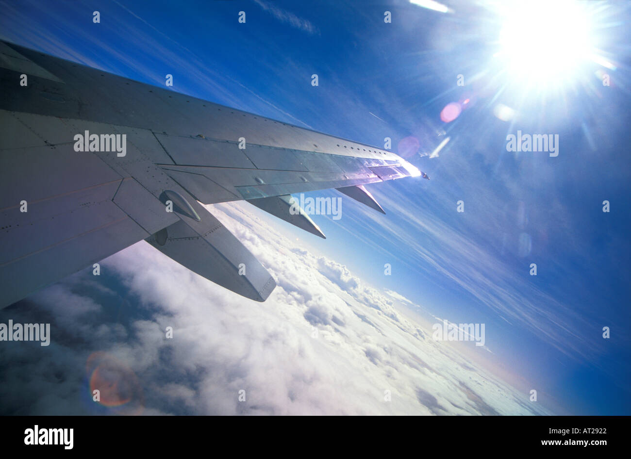 Airplane window view with clouds and sun shining on wing Stock Photo ...