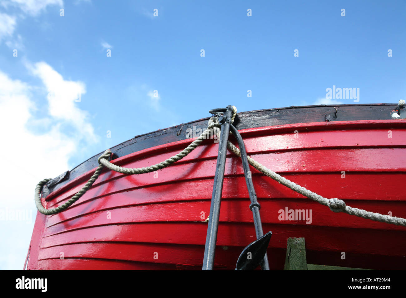 A red rowing boat in the a bright blue sky The boat looks like its in ...