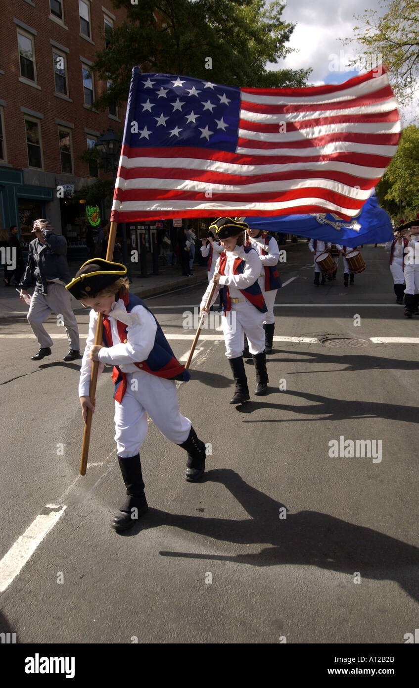 Boy dressed as a patriot walking with an american flag during a 4th of ...