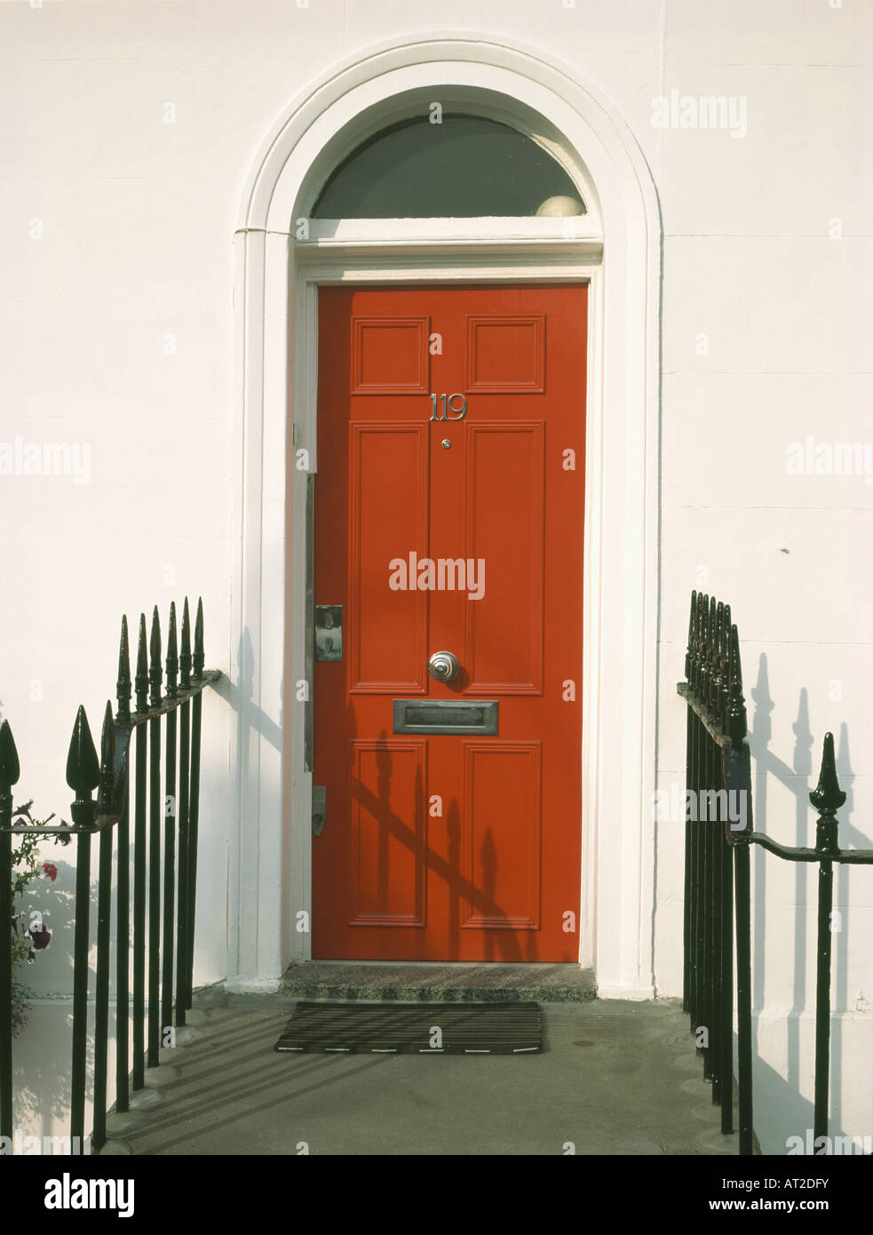 Fanlight and traditional red front door and black iron railings Stock ...