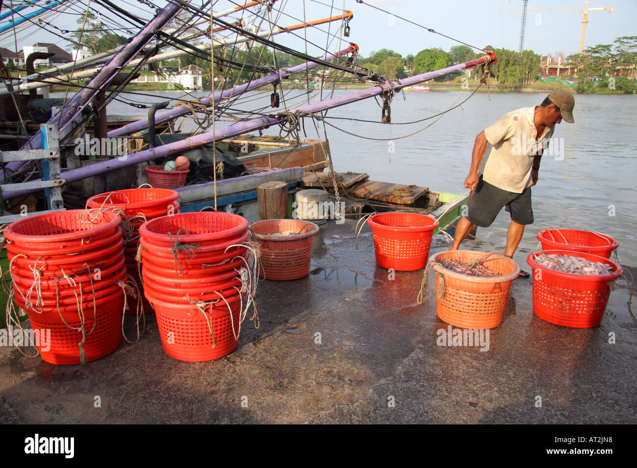 Fishermen unloading their haul onto the fish market pier in Kuching ...
