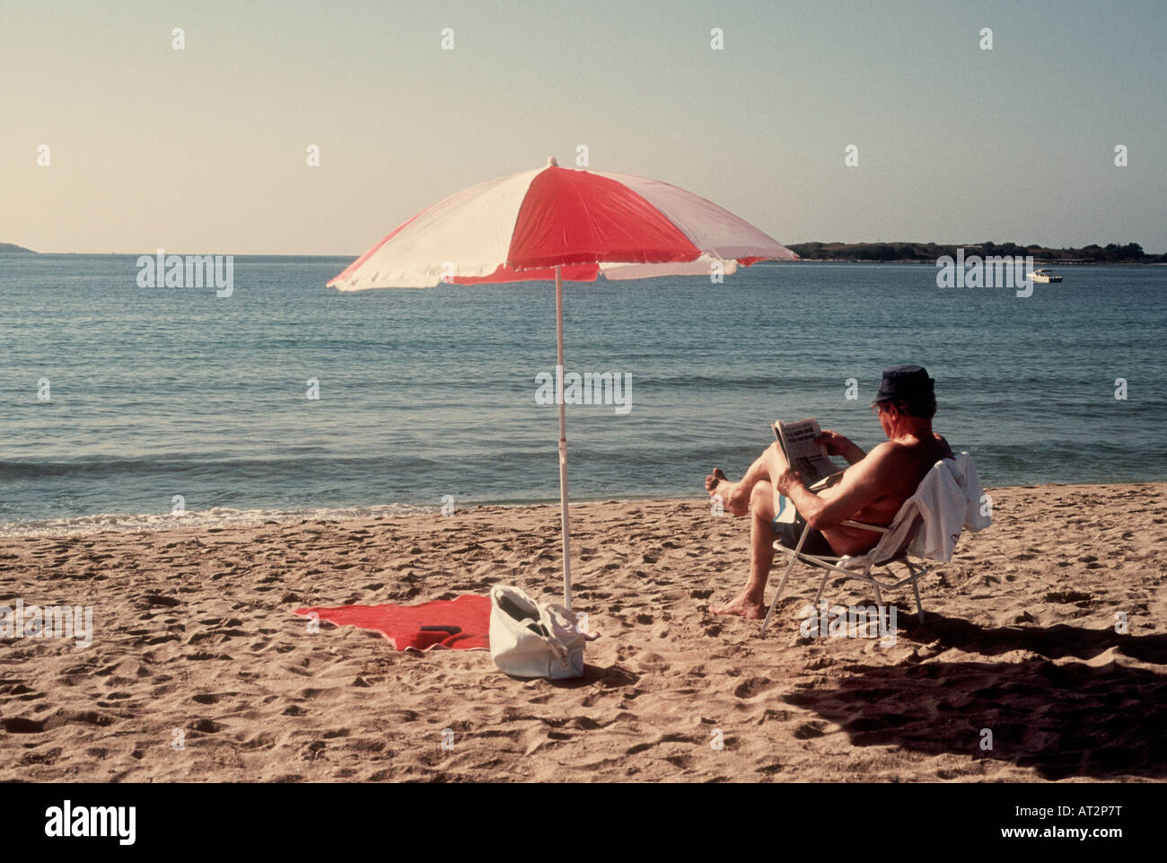 Man reading newspaper on the beach Stock Photo - Alamy