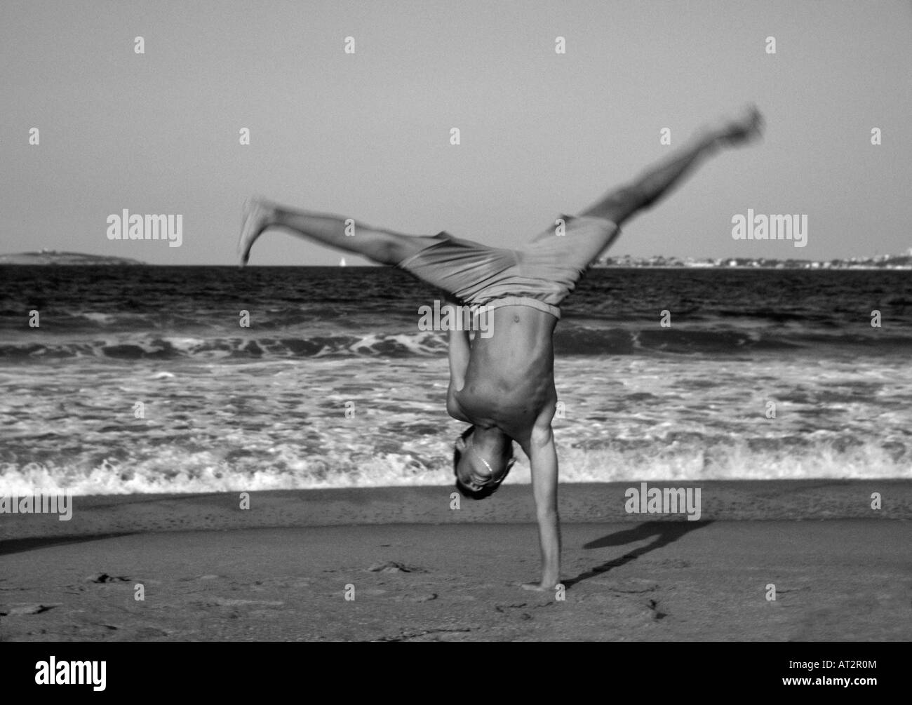 Boy performs hand stand on the beach Stock Photo - Alamy