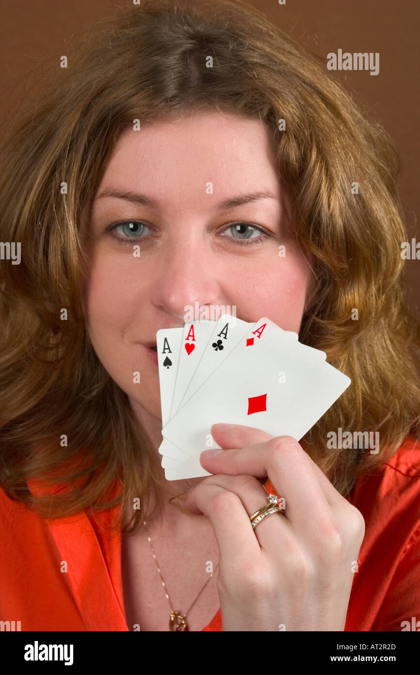 Young woman with red hair holding four aces Model Released Stock Photo ...