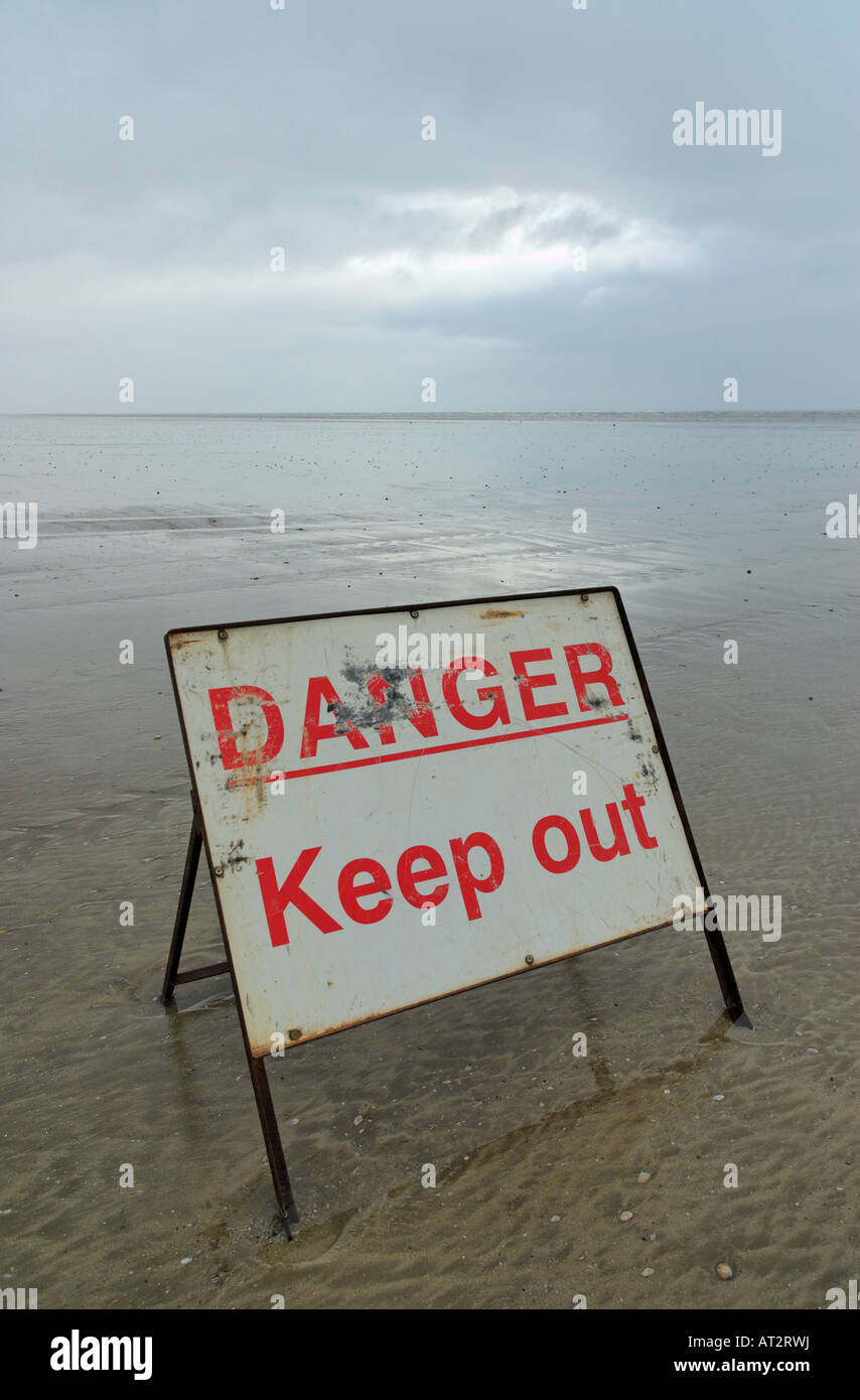 Danger keep out sign on an empty beach at Pendine sands overcast grey ...