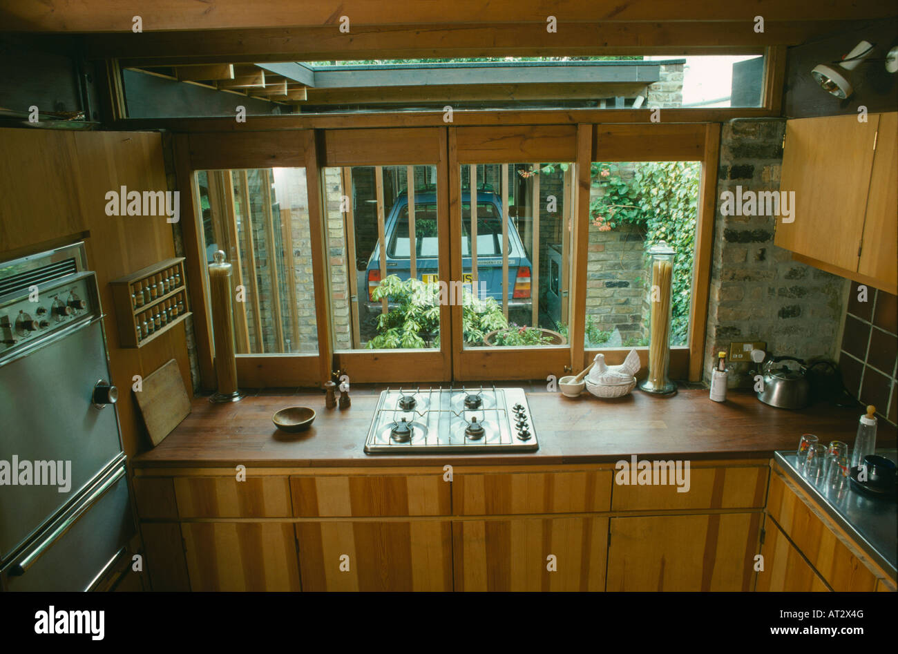 Seventies kitchen with gas hob in wood worktop in front of window with ...