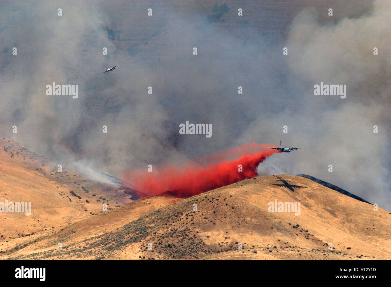 A C-130 Hercules airplane drops fire retardant on the Homestead Fire in ...