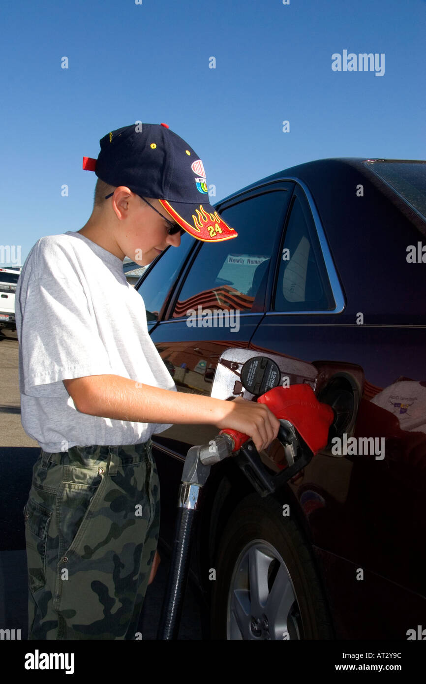 A nine year old boy pumps gasoline into a car at a gas station in Boise ...