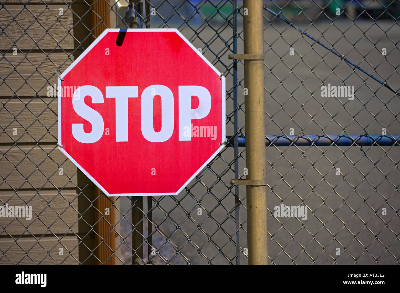 stop sign hung on a chain link fence At an industrial location Stock ...
