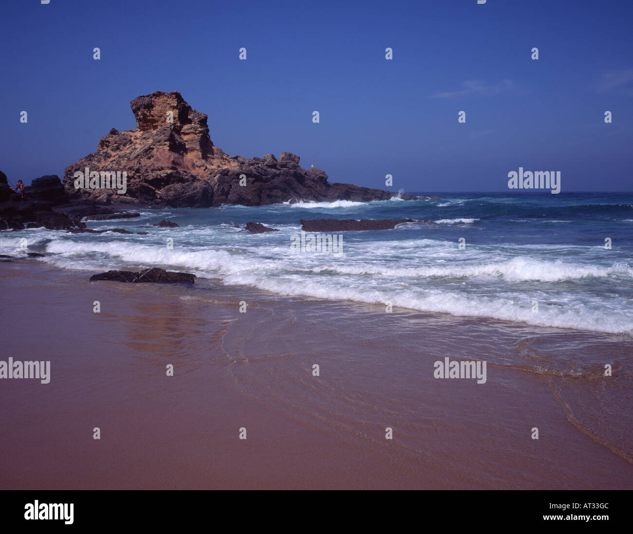 Sandy beach with rock outcrop and waves on the south west coast of ...