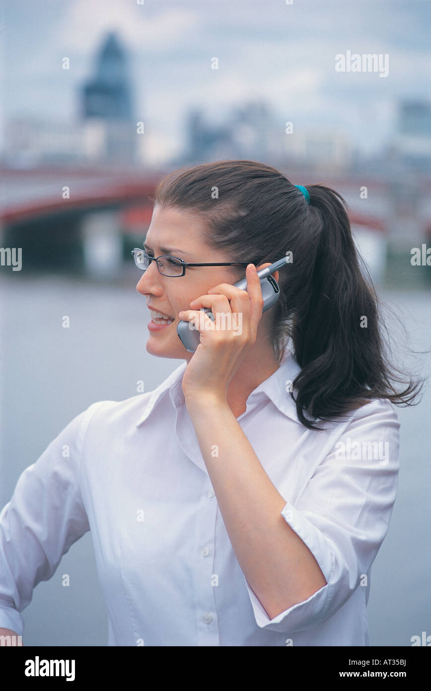 A young woman speaking on a mobile phone, side profile Stock Photo - Alamy