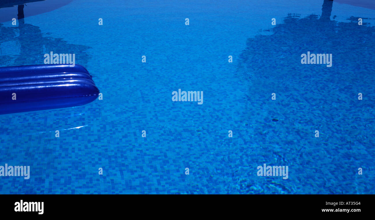 Blue inflatable sunbed floating on a blue tiled swimming pool Stock ...