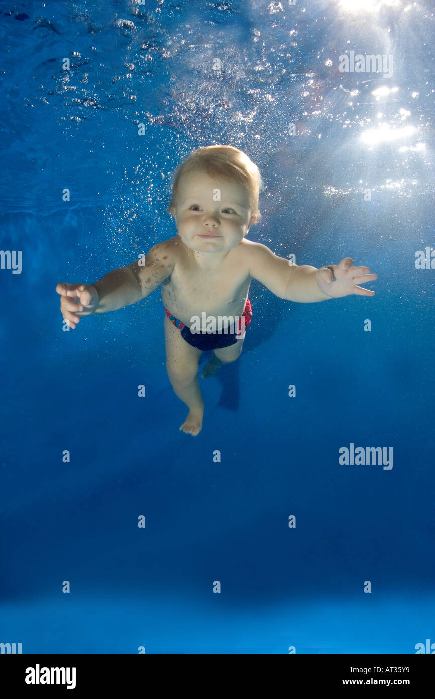 Baby underwater in pool on blue background Stock Photo - Alamy