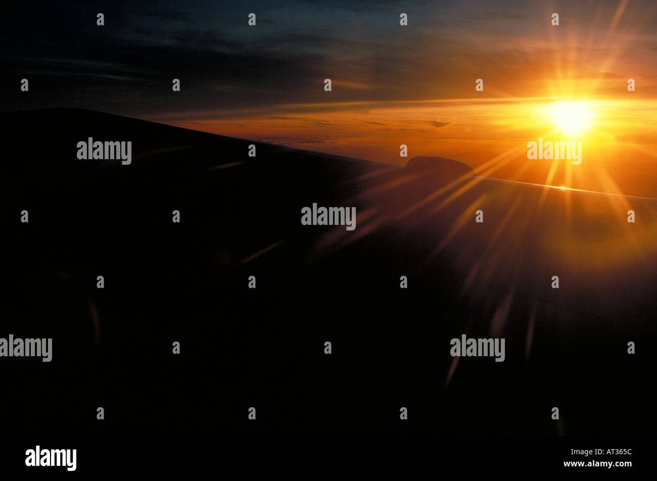 Sun setting over airplane wing from airplane in flight to new ...