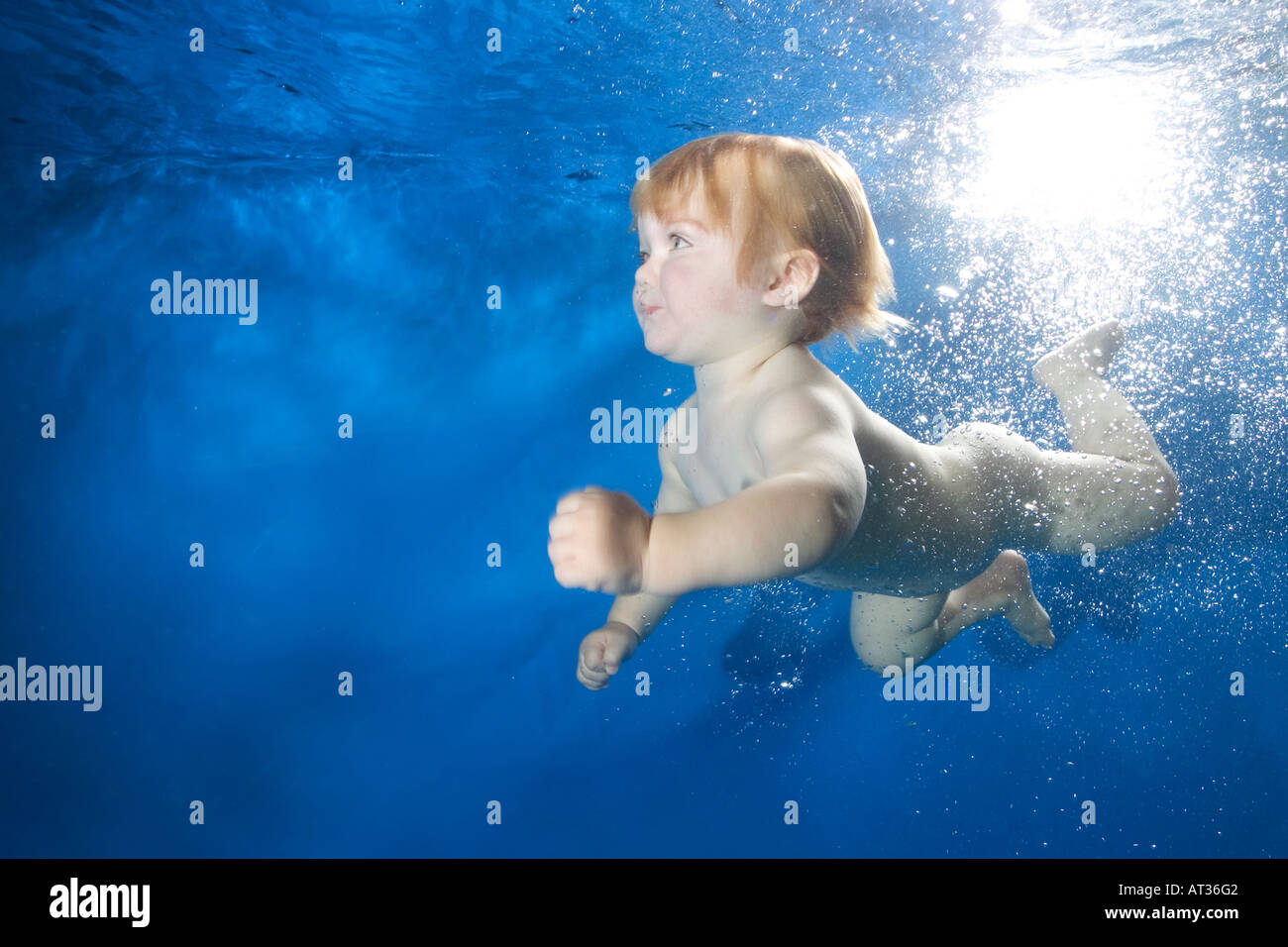 Baby underwater in pool on blue background Stock Photo - Alamy