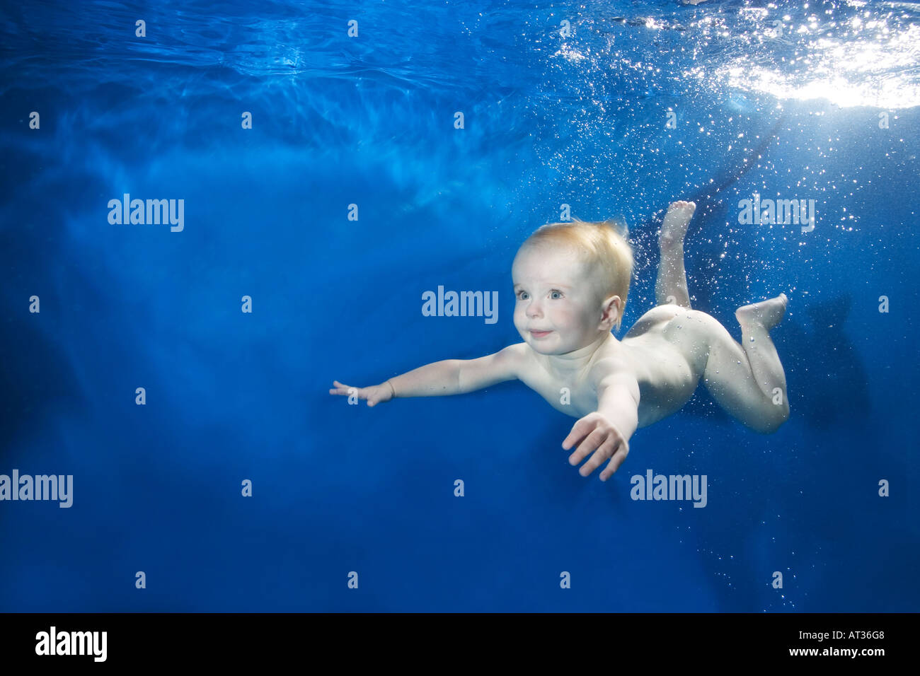 Baby underwater in pool on blue background Stock Photo - Alamy