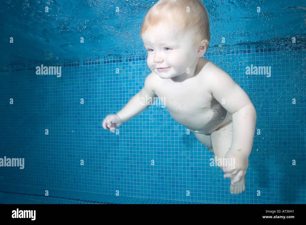 Baby underwater in pool on blue background Stock Photo - Alamy