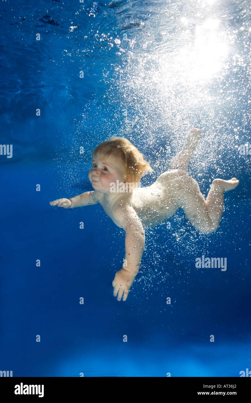 Baby underwater in pool on blue background Stock Photo - Alamy