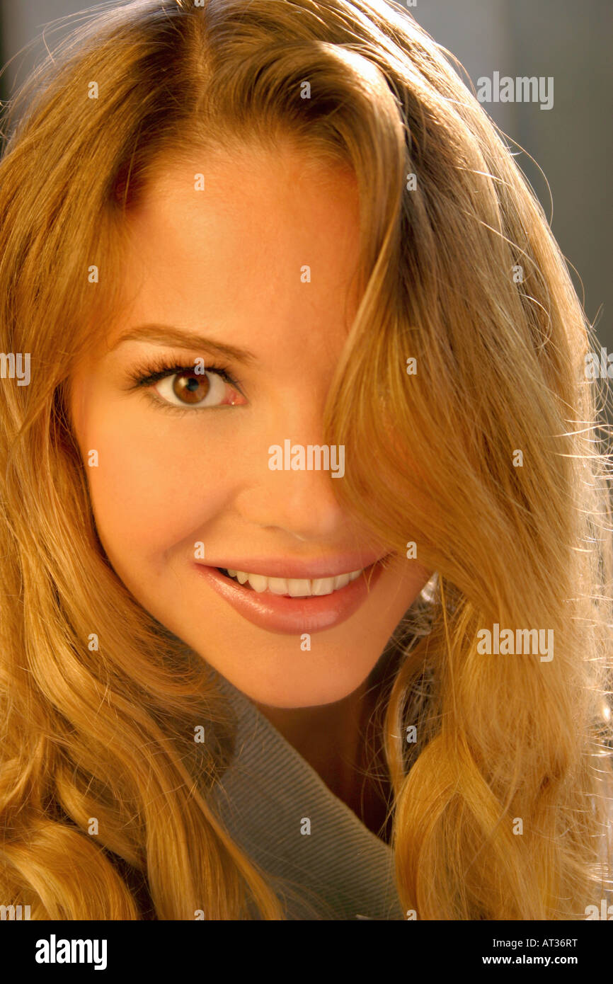 A portrait of a woman with long blonde hair over one eye Stock Photo ...