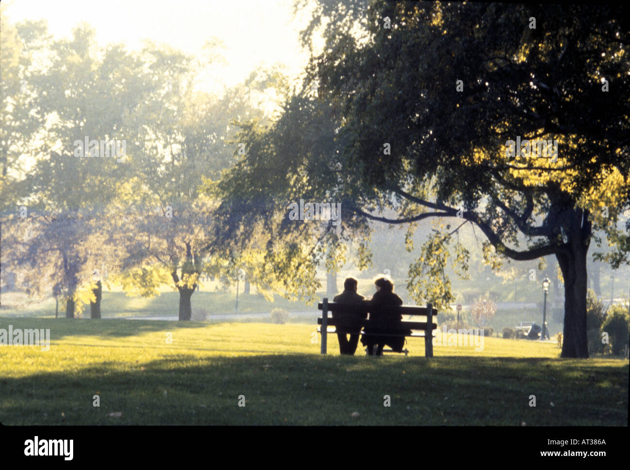 Two person seating on a park bench Stock Photo - Alamy