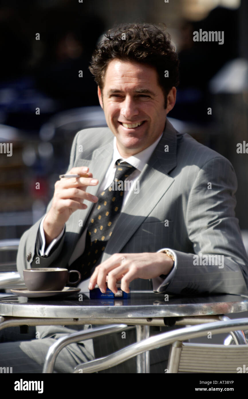 A man holding a cigarette, smiling Stock Photo - Alamy
