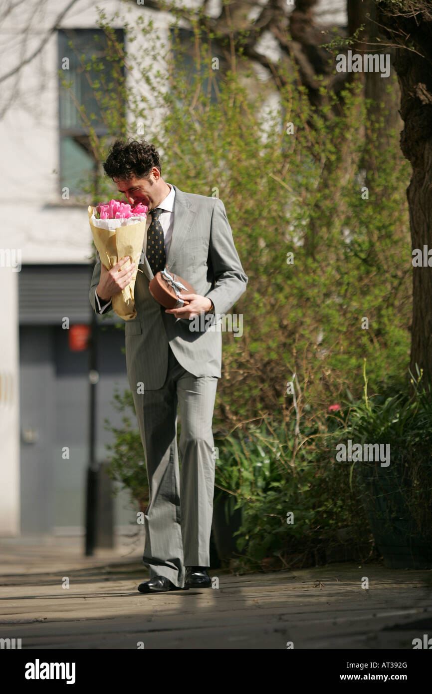 A man smelling a bunch of flowers Stock Photo - Alamy
