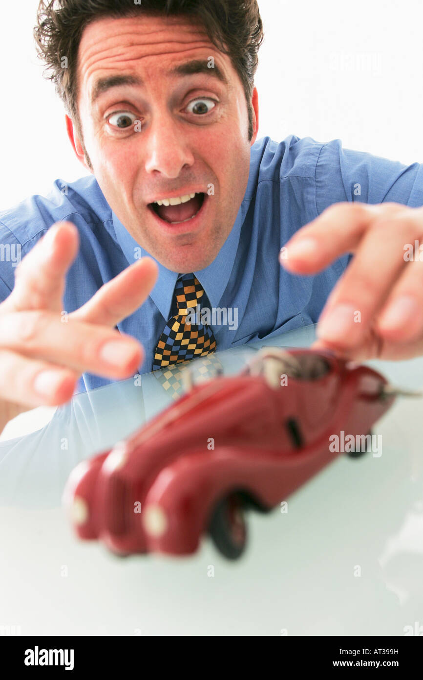 A man playing with a red toy car Stock Photo - Alamy