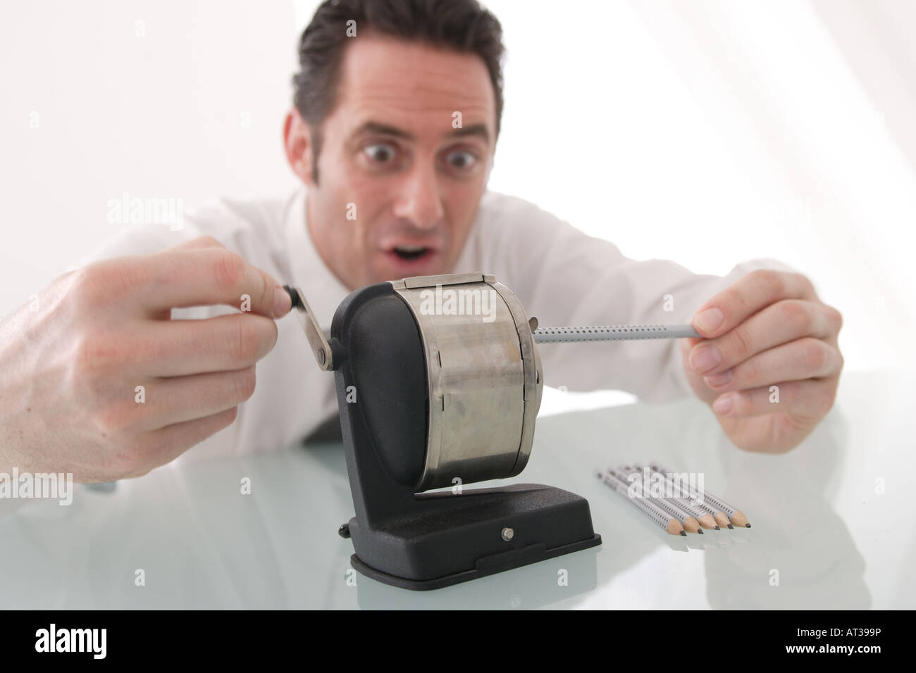 A man sitting at his desk sharpening pencils Stock Photo - Alamy