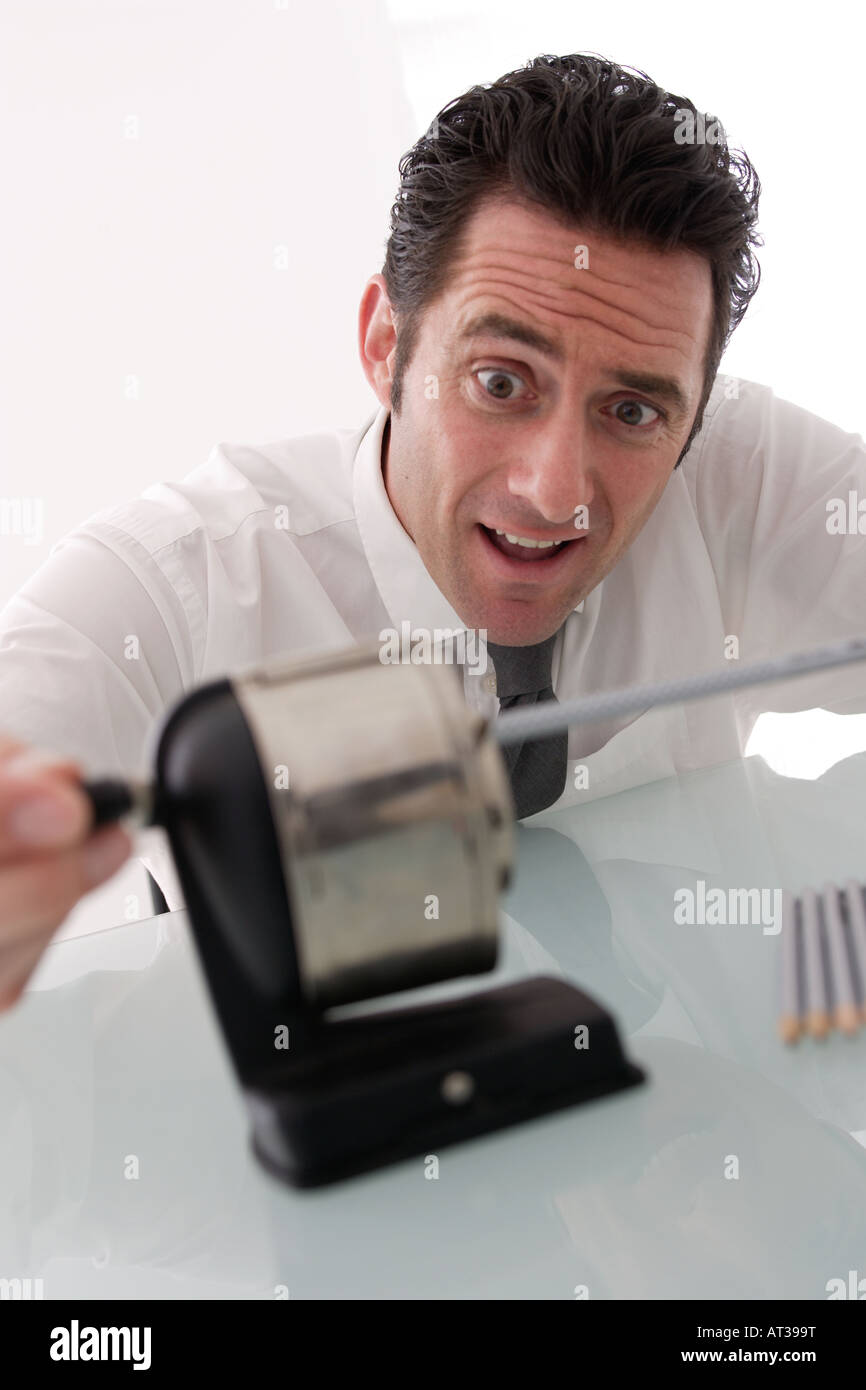 A man sitting at his desk sharpening pencils Stock Photo - Alamy
