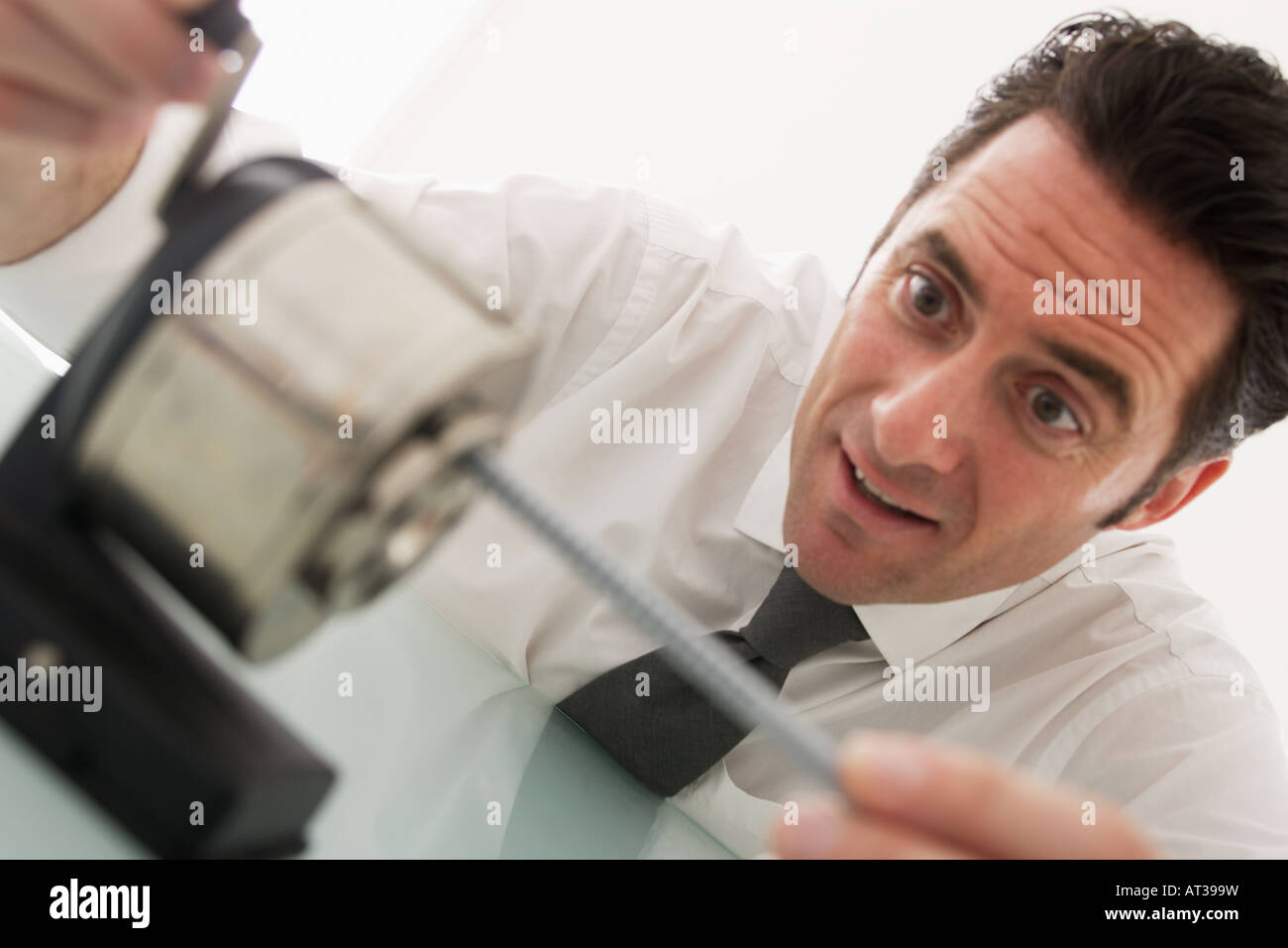 A man sitting at his desk sharpening pencils Stock Photo - Alamy