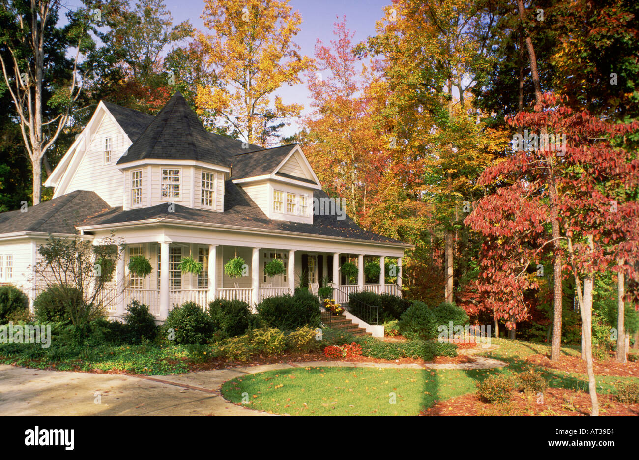 Fall folliage surrounds a large white two story upper middle class ...